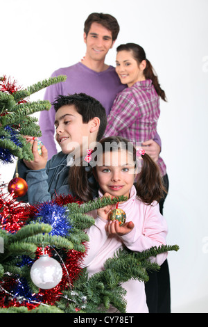 Family gathered around a Christmas tree, using a tablet Stock Photo - Alamy