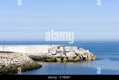 Concrete harbour wall, harbour light and sea defenses protect the ...