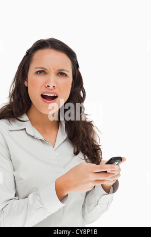Brunette frowning while using her mobile Stock Photo - Alamy
