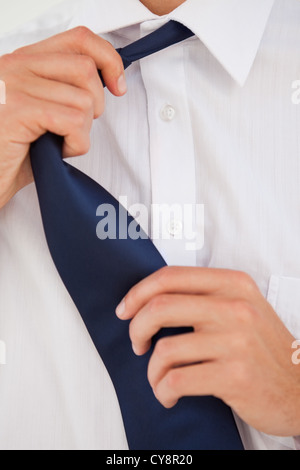 Close-up of a man undoing his tie against white background Stock Photo ...