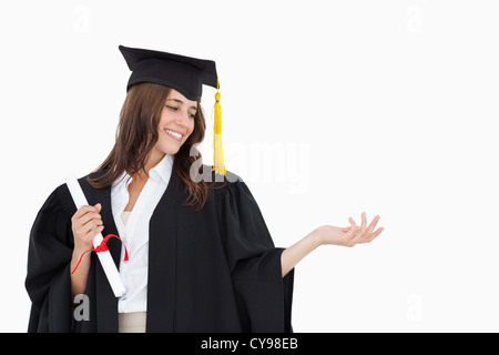 Young caucasian woman holding degree over isolated background with ...