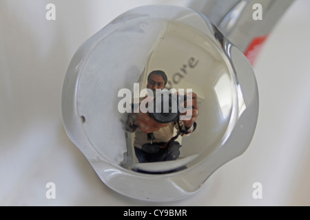 Reflection of photographer in Modern faucet with stainless steel ...