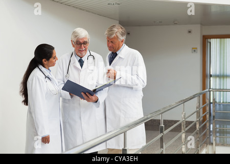 Three doctors smiling and talking in a meeting Stock Photo - Alamy