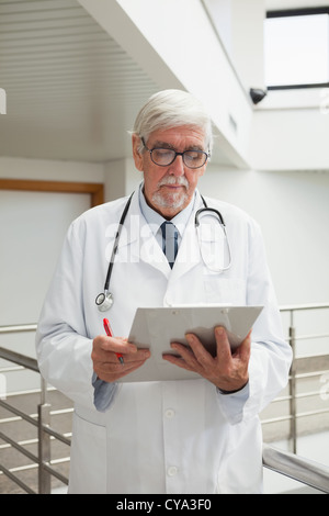 Doctor reading patient files Stock Photo - Alamy