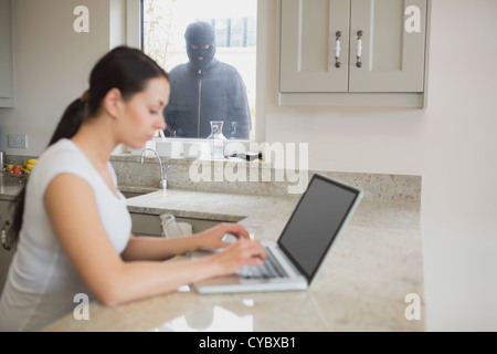 Burglar observing woman in the kitchen Stock Photo - Alamy