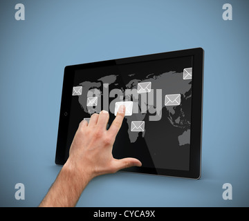 Hand pointing at tablet computer with email symbols and world map ...