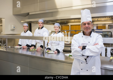 Head chef standing with team behind him Stock Photo - Alamy