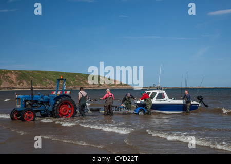 Tractor landing fishing boat Filey North Stock Photo - Alamy