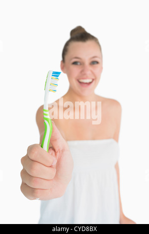 Beautiful young happy woman with toothbrush and paste on brown ...