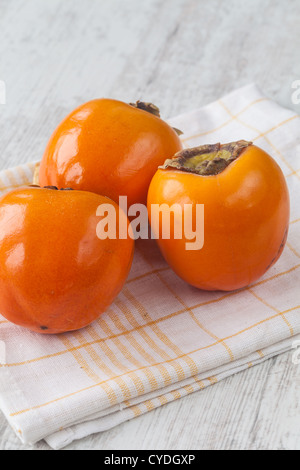 Persimmon fruit on wooden table with blurred garden background Stock ...