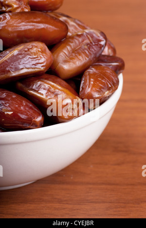 Dates fruit in bowl, background is date fruit tree Stock Photo - Alamy
