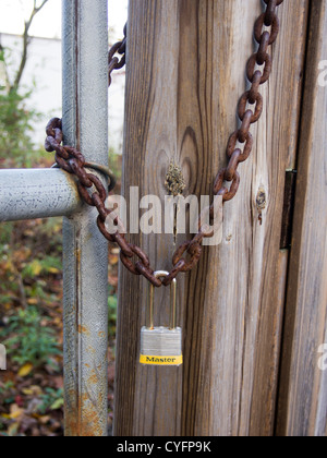 Close-up of Master Lock key lockbox attached to metal fence with green ...