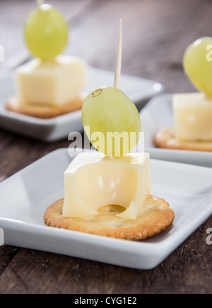 Pieces of Cheese on a Cracker topped with a Grape Stock Photo - Alamy