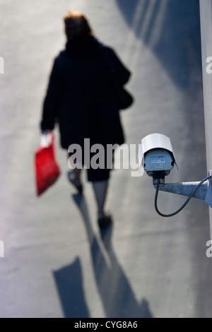A surveillance CCTV camera watches over a passing commuter, their ...