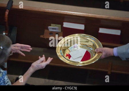 The offering plate is passed down a pew during service at Saint Martin ...