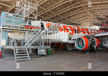 Passenger jet planes undergoing maintenance in a busy aircraft hangar ...
