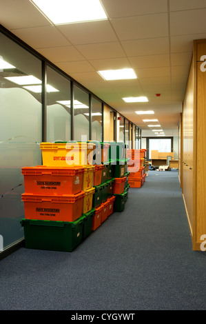 Plastic boxes in red, green, white and yellow colors on racks for ...
