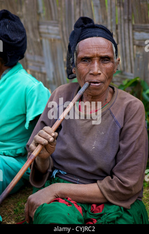 Tribal women smoking traditional pipe on the vegetable market in Ruma ...