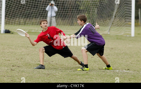 Teenage boy guards his opponent during an Ultimate frisbee game at a ...