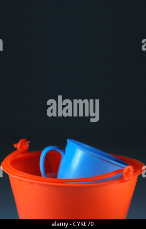 Blue empty bucket with red handle on sand background Stock Photo - Alamy