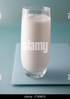 A vertical closeup of a glass of a cold milk tea on a wooden table ...