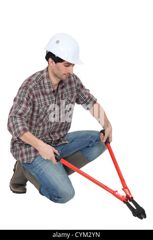 Man kneeling with bolt-cutter Stock Photo - Alamy
