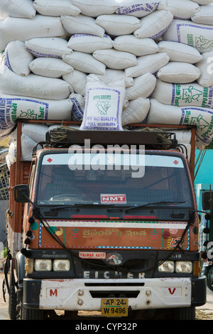 Overloaded Indian lorry carrying sacks of rice and farm workers ...
