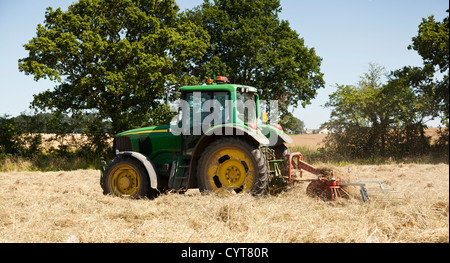 Working Agricultural Tractor with machinery for making furrows in field ...