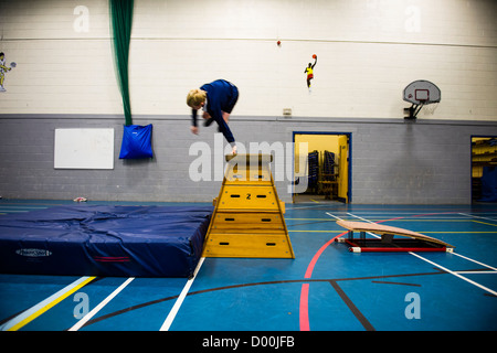 A boy vaulting in a Physical education class in the gymnasium at a ...