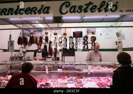 Food market Spain; A butcher selling meat and cheese in his food stall ...