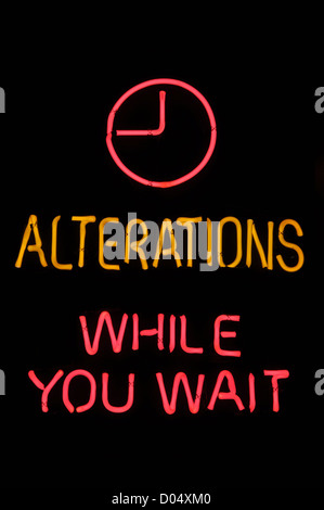 Alterations While You Wait Neon Sign Stock Photo - Alamy