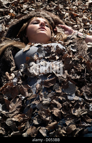Woman buried in oak leafs Stock Photo - Alamy