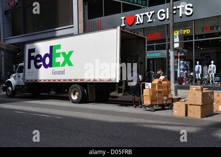 New York City: FEDEX driver with packages on a dolly prepares to Stock ...