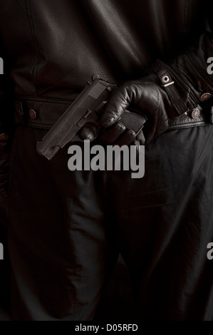 Man wearing gun behind his back Stock Photo - Alamy