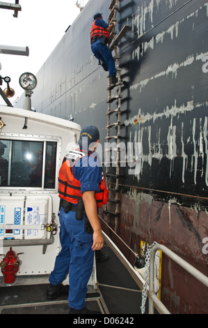 US Coast Guard agents climb rope ladder to board a tanker ship, Port ...