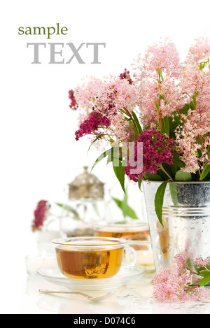 Healthy herbal tea in a sample spoon next to a teacup Stock Photo - Alamy