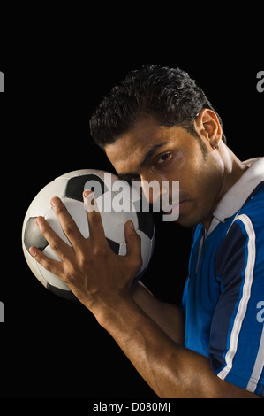 Depressed football player holding ball on field Stock Photo - Alamy
