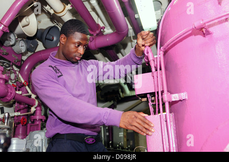 Boatswain's Mate 3rd Class adjusts a line while setting up an underway ...