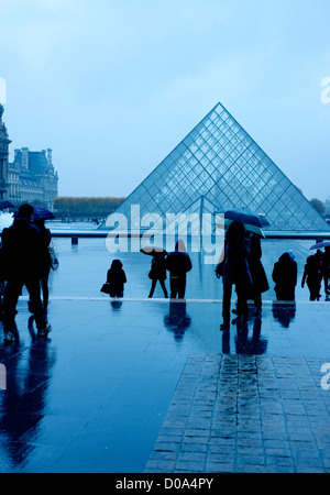 People walking on a cold, wet, windy, rainy beach with donkeys Stock ...