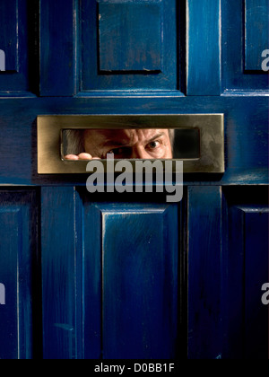 man looking through letter box- trying to break in- key in door Stock ...