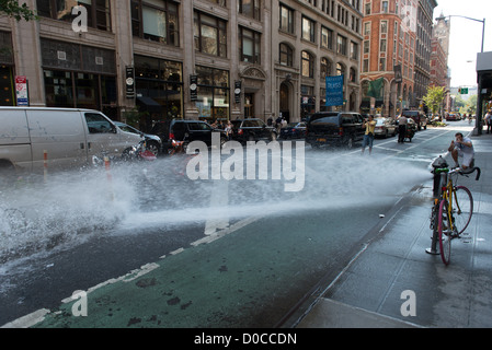 Spray of water from broken johnny pump on Manhattan, New York Stock ...