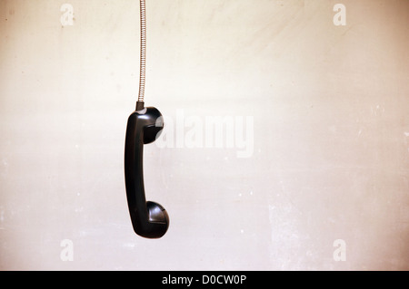 Hanging vintage phone receiver over a grunge background Stock Photo - Alamy