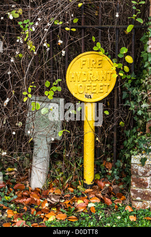 Yellow fire hydrant concrete marker post Stock Photo - Alamy