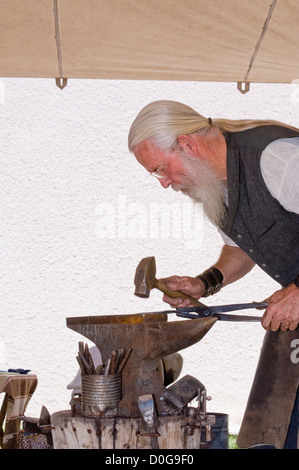 A blacksmith making horseshoes at his forge, at the New Mexico Farm and ...