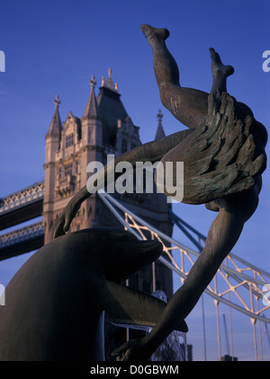 Tower Bridge and Dolphin and a boy statue at dusk, North Bank, London ...