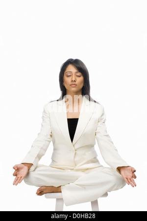 Young businesswoman meditating on the white Stock Photo - Alamy