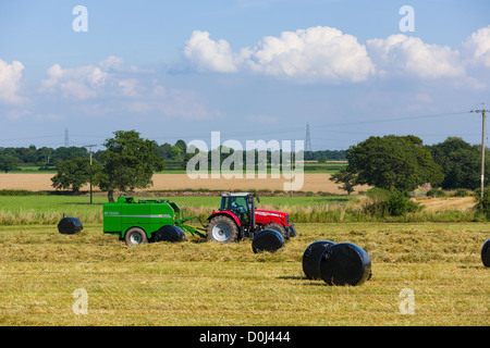 Tractor making bales of hay Stock Photo - Alamy
