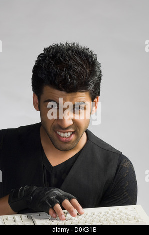 Angry man typing on a computer keyboard Stock Photo - Alamy