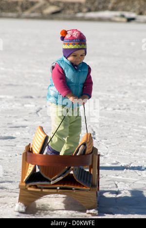 Child pulling sled on Wallowa Lake, Oregon Stock Photo - Alamy