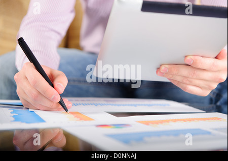 Young businessman analyzing charts. Low angle view Stock Photo - Alamy